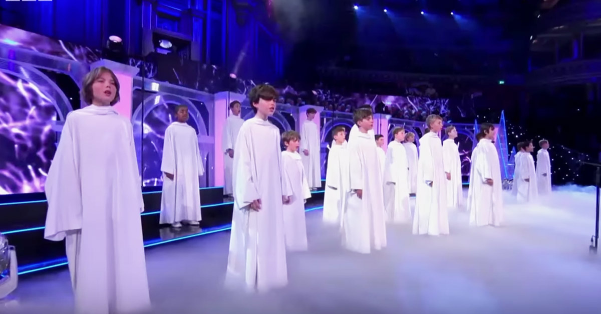 Un choral de jeunes garçons entre sur scène, à la seconde où ils ...
